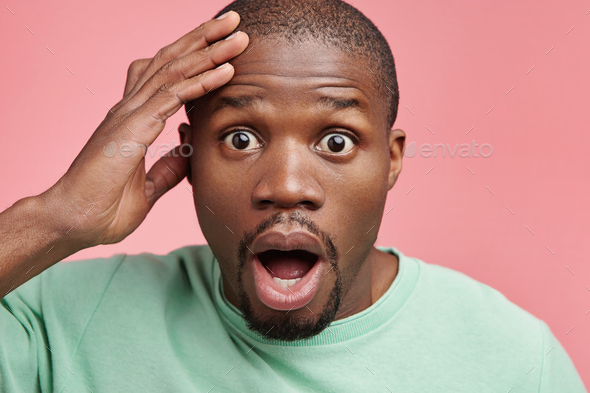 Close up portrait of dark skinned man with popped out eyes and jaw ...