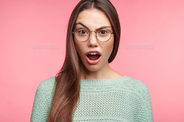 Perplexed indignant female with Asian appearance, keeps mouth opened ...