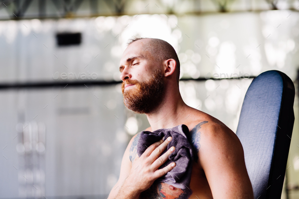 European tattooed bearded exhausted strong tired man looks sweaty after ...
