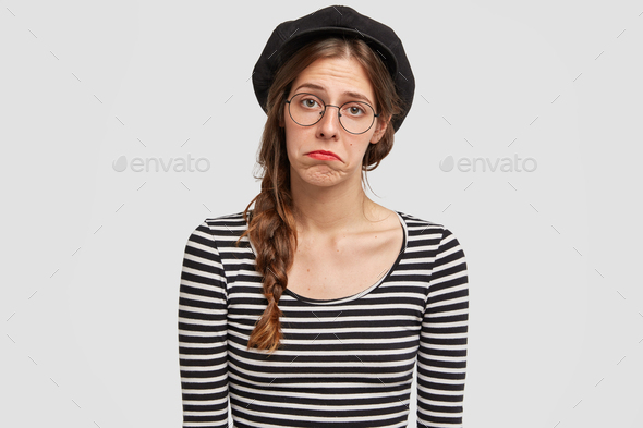 Discontent beautiful female with displeased expression, curves lips and ...