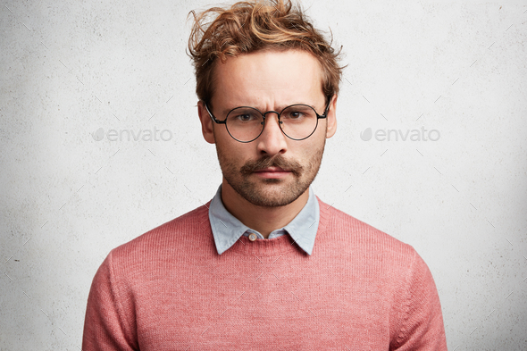 Horizontal shot of grumpy angry man frowns face in dissatisfaction ...