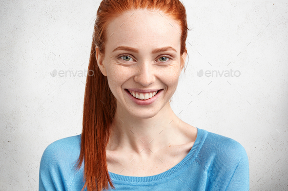 Close up shot of glad ginger female has broad smile, white teeth ...