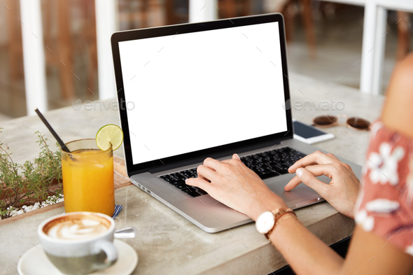 Cropped imgae of female employee types on keyboard of modern portable ...