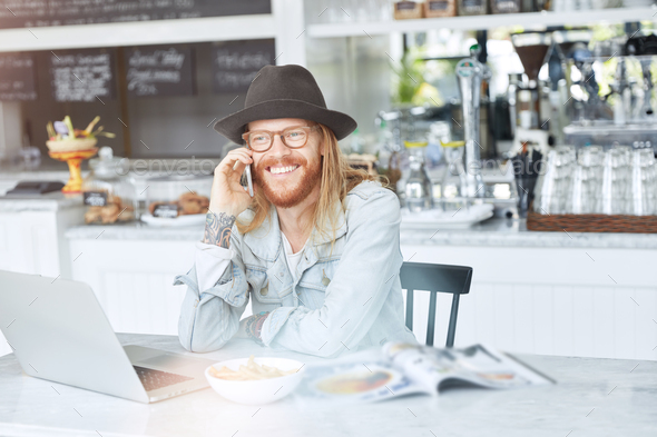 Glad positive male journalist with specific appearance conducts ...