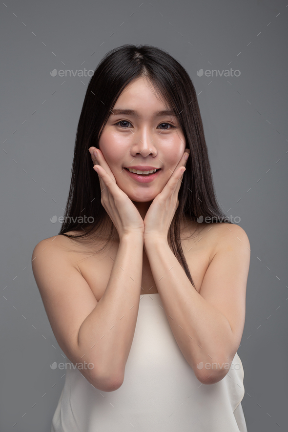 The woman wore a white strapless dress and hands touch her face. Stock ...
