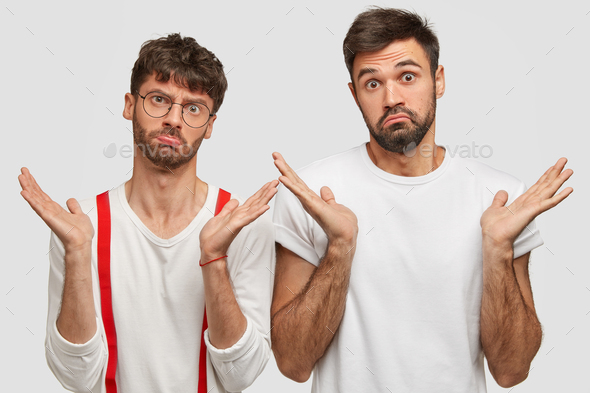 Photo of two carefree clueless bearded men shrug hands spread aside ...