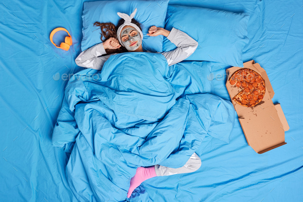 Photo of relaxed woman cares about her appearance stretches arms after ...