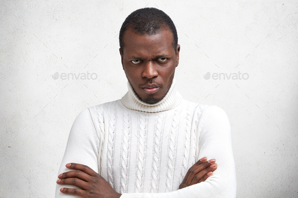 Portrait of displeased male model looks angrily with sullen expression ...