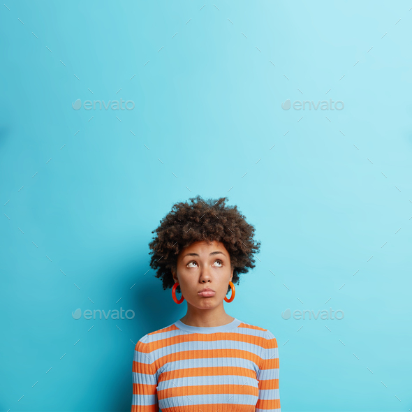Vertical shot of unhappy dark skinned woman looks with gloomy ...