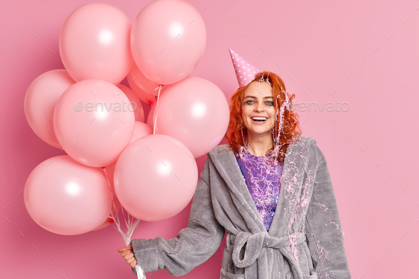 Smiling woman satisfied after noisy party has spoiled makeup wears cone ...