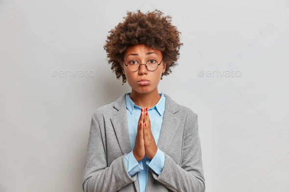 Unhappy young African American woman with curly bushy hair looks with ...