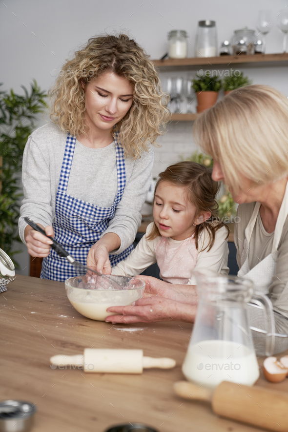 Three generations of women mixing ingredients in a bowl Stock Photo by ...