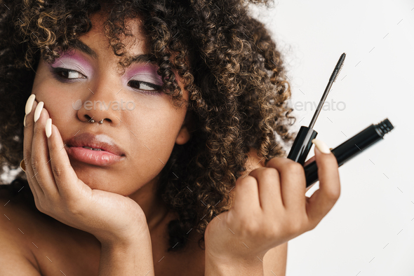 Beautiful thinking african american girl posing with mascara Stock ...