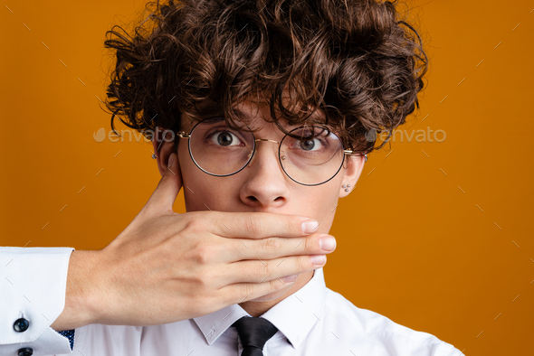 Shocked male student standing wearing uniform Stock Photo by vadymvdrobot