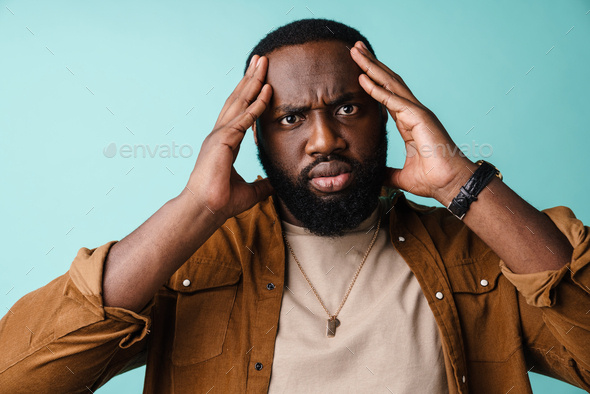 Angry upset african man standing isolated Stock Photo by vadymvdrobot