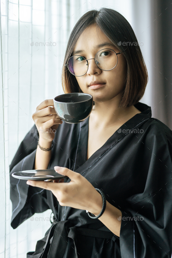 Women wearing black robes, handing coffee in the bedroom. Stock Photo ...
