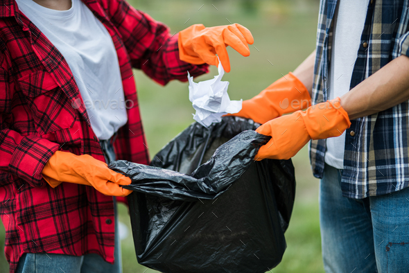 Men and women help each other to collect garbage. Stock Photo by ...