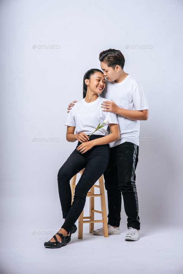 Two women lovers grab another shoulder and sit in a chair. Stock Photo ...