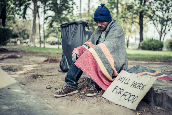 Beggars, wrapped in cloth, then wearing a hat and sitting down beside ...