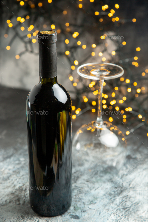 Vertical view of red wine bottle for celebration and a fallen empty ...