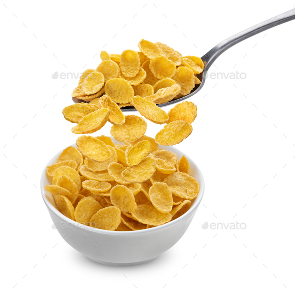 Corn flakes falling from spoon into bowl isolated on white background ...