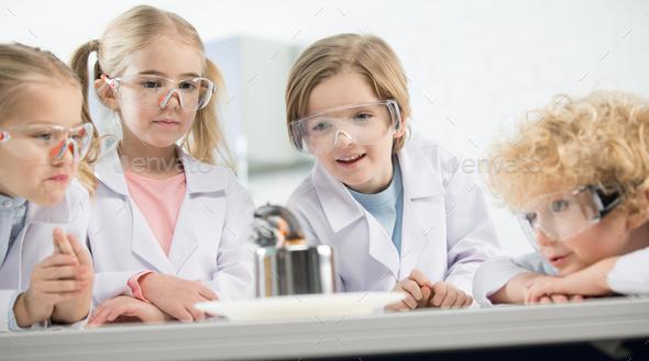Four kids wearing protective glasses in science laboratory Stock Photo ...