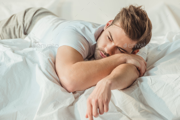 handsome young man relaxing in bed at morning Stock Photo by ...