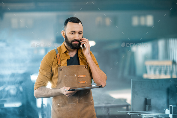 Factory worker with tablet and phone at the manufacturing Stock Photo ...