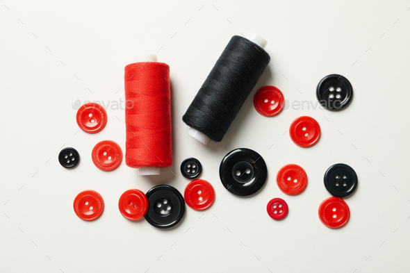 Red and black threads and buttons on white background Stock Photo by ...