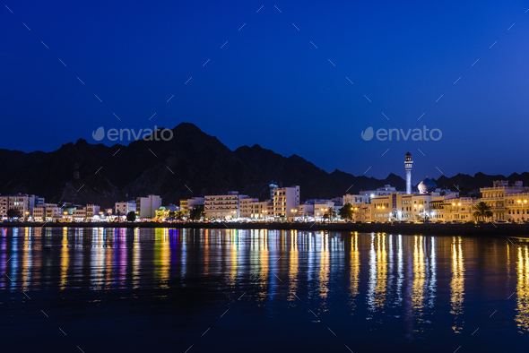 The city of Muscat, waterfront lights, mountains behind, at night Stock ...