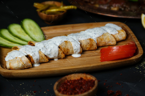 meat roll pancake cucumber tomato sumakh sour cream sauce side view ...