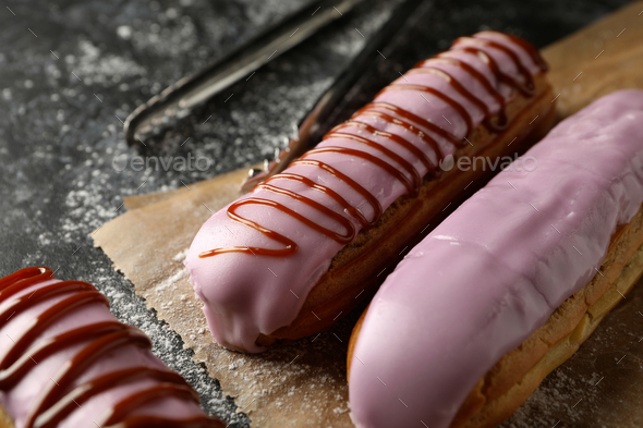 Baking paper with tasty eclairs on black smokey background Stock Photo ...
