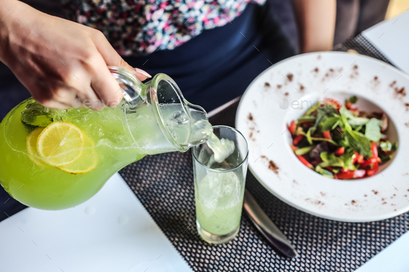 man pouring citrus lemonade in glass lemon lime sparkling water side ...