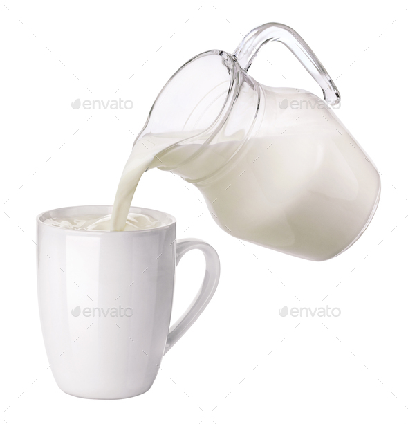 Pouring milk from glass jug into cup isolated on white background Stock ...