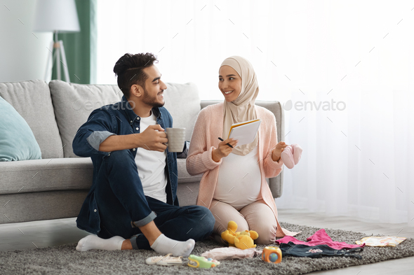 Happy pregnant muslim couple getting geady for childbirth, making ...