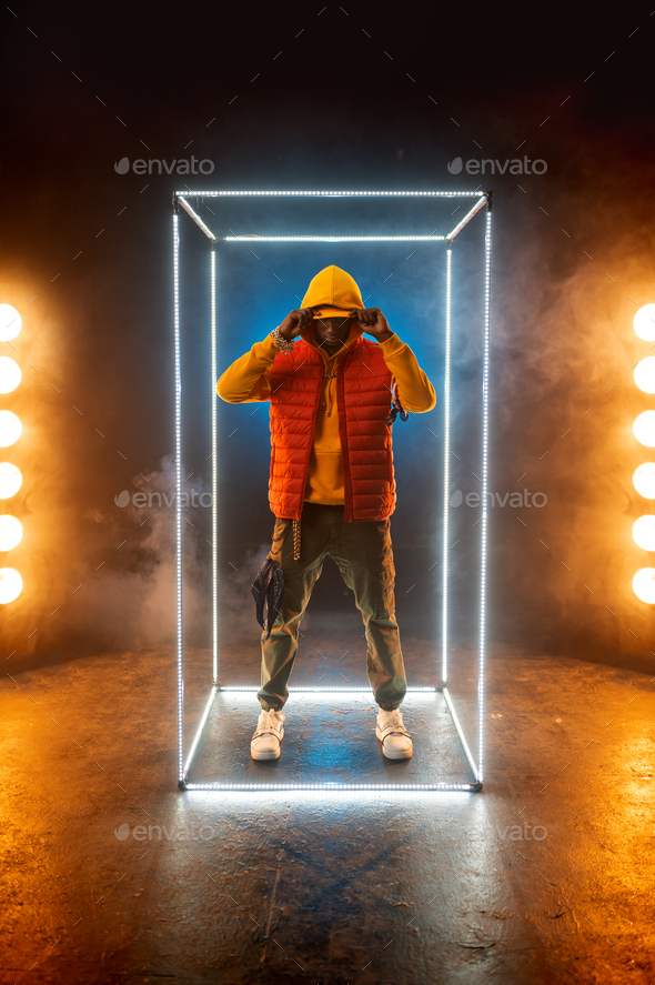 Stylish rapper poses in illuminated cube Stock Photo by NomadSoul1