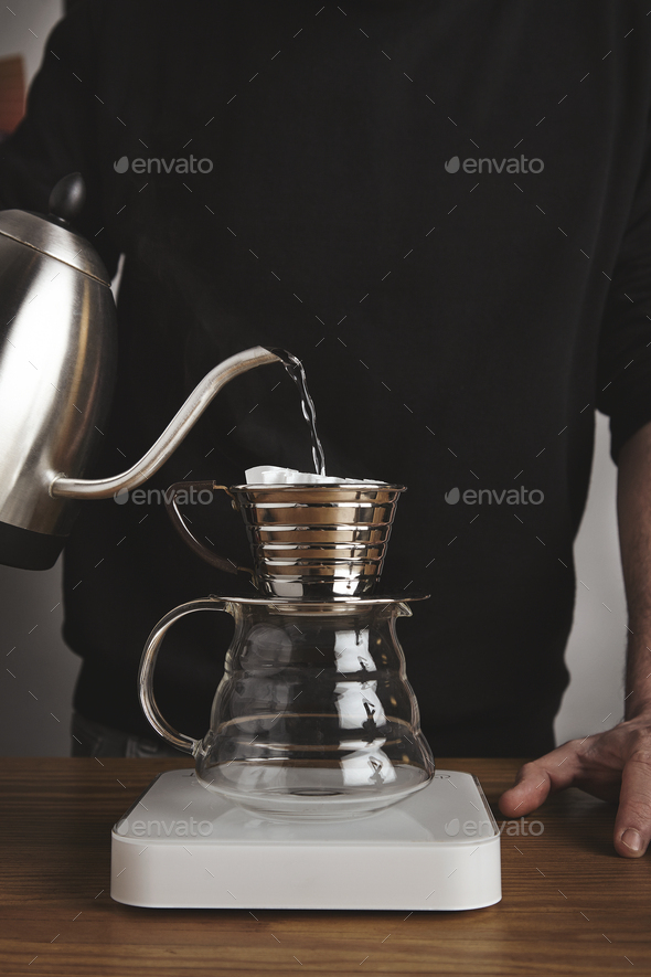 Barista spills boiled water in drip coffee maker Stock Photo by bublikhaus