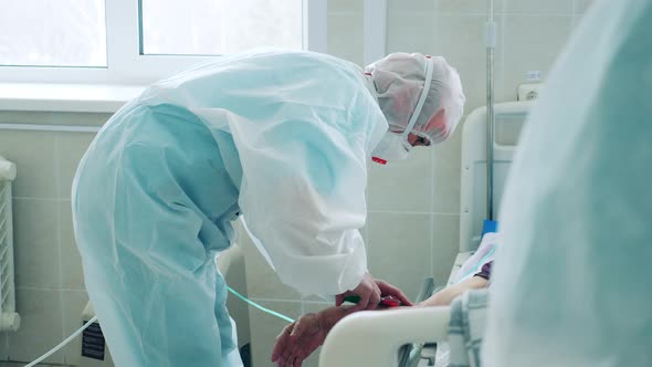 Doctor in a Hazmat Suit Is Giving an Injection To a Patient, Stock Footage
