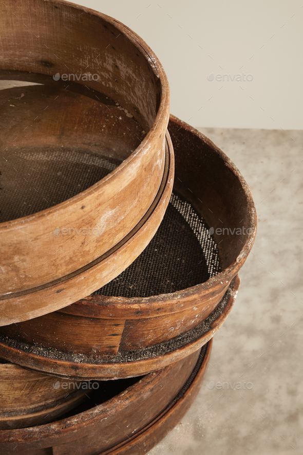 Old vintage wooden kitchen sieve isolated on white stone marble table ...