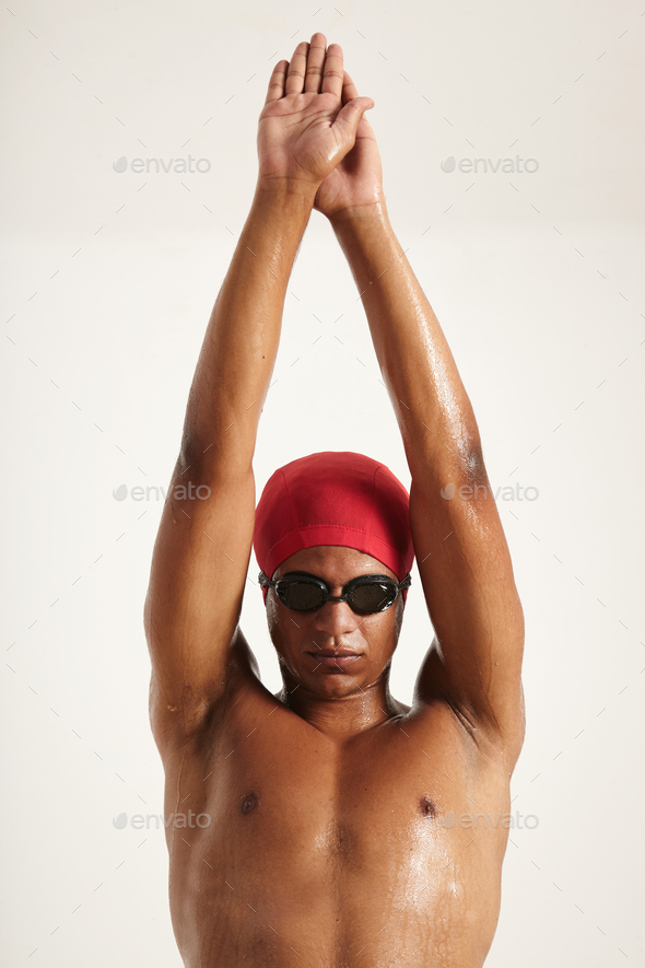 Young black swimmer raising hands up to dive Stock Photo by bublikhaus