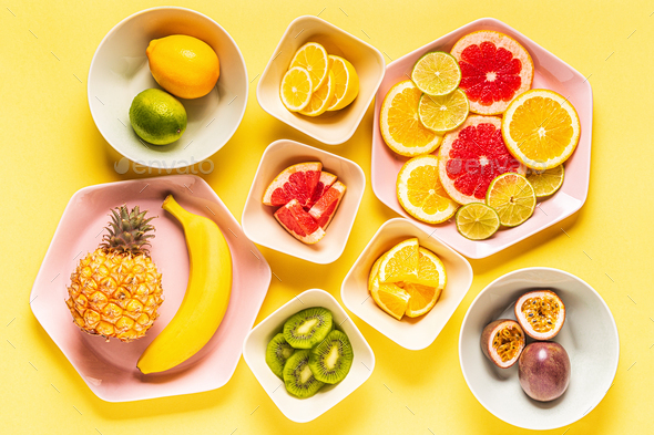 Tropical fruits whole and slices on plates Stock Photo by tatiana_bralnina