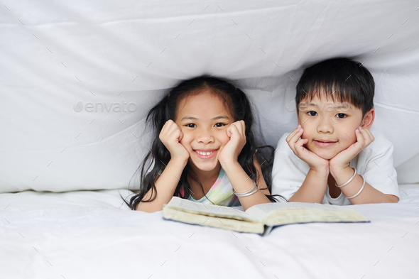 Siblings reading together Stock Photo by DragonImages | PhotoDune