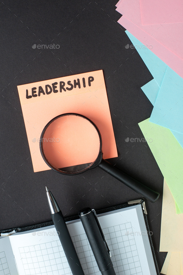top view leadership note with stickers pens and magnifier on dark ...