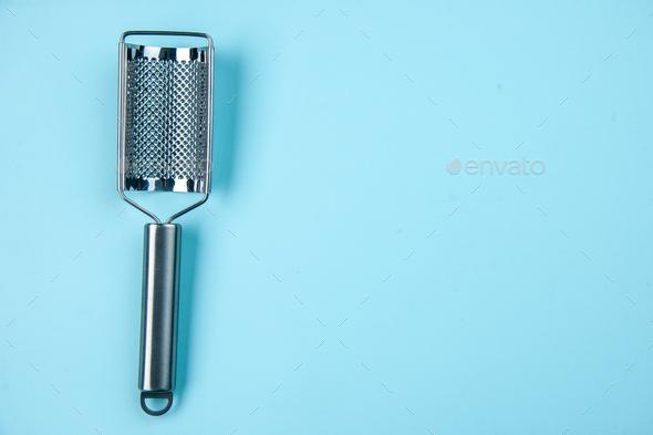 Top view of stainless kitchen tool lying on the right side on pastel ...