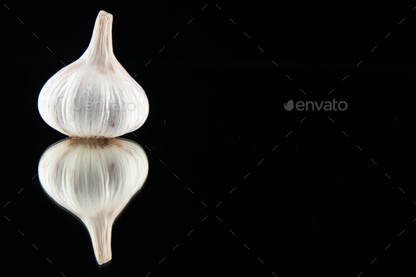 Top view of fresh garlic pod on the right side on black background with ...