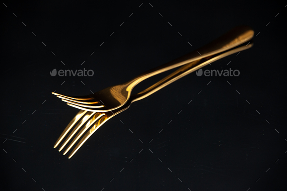 Above view of shiny golden fork on black background with free space ...