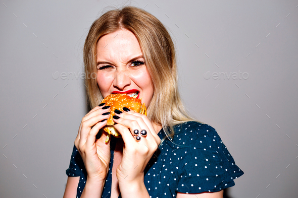 Indoor bright flash image of woman eating big junky burger, Stock Photo ...