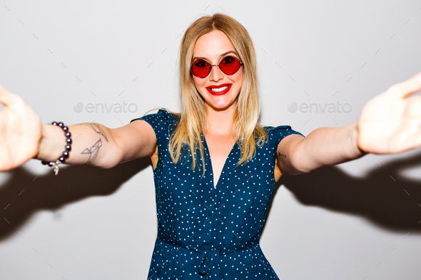 Indoor flash bright portrait of hipster stylish woman posing near white ...