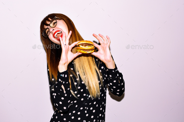 Indoor bright flash image of woman eating big junky burger, Stock Photo ...