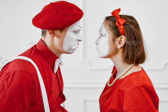 Mime artists in red costumes look at each other Stock Photo by NomadSoul1